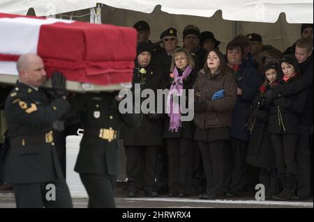 Family members watch as pall bearers carry the casket of Sergeant Kirk ...
