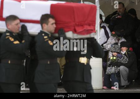 Family members watch as pall bearers carry the casket of Sergeant Kirk ...