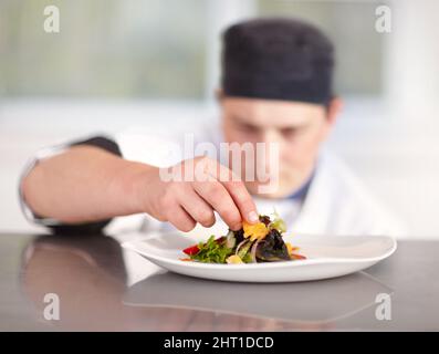 I do everything to perfection. Young chef putting the final perfect ...