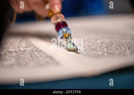 Person reading an ancient manuscript with the help of a vintage ...