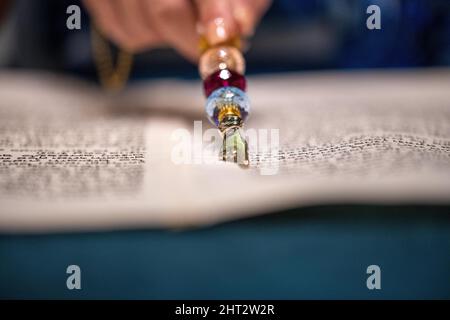 Person reading an ancient manuscript with the help of a vintage ...