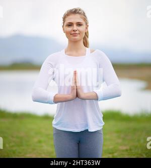 The stress-less workout. an attractive woman doing yoga at the park ...