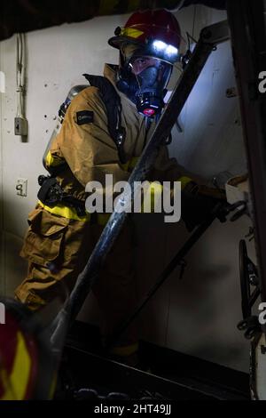 US Navy Damage Control Technician 1ST Class Jeffrey Reynolds assist ...