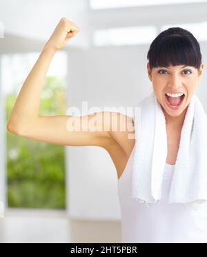 Reaching for her fitness goals. an attractive young woman working out ...