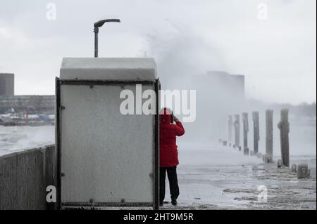 Woman take photos with phone during Winter storm on the pier Stock ...