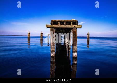 Tall wooden port structure in blue water Stock Photo - Alamy