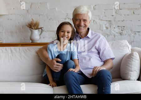 Happy friendly family, grandparent and grandson sitting on sofa and ...