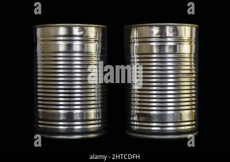 Closeup shot of two metal cans filled with fresh cherries on a pink ...