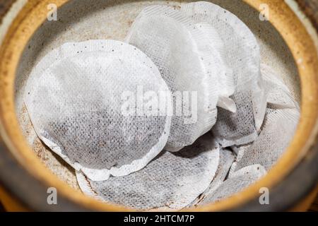 Round tea bags stored in an earthenware container Stock Photo - Alamy
