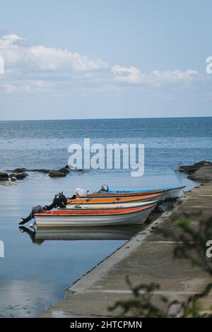 Calm beach with moored boats and a jetty on Goree Island, Senegal Stock ...