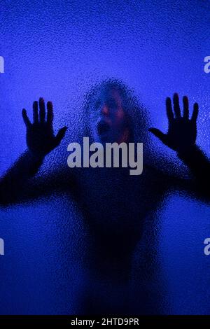 Shadow of woman screaming behind the glass, domestic violence concept ...