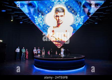 Boxer on a screen in a pavilion and people standing and watching it ...