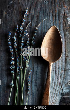 Wooden spoon and book on a wooden board with a checkered tablecloth ...