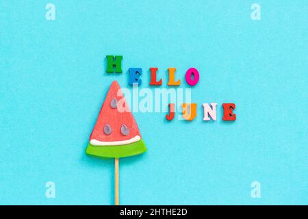 Hello June colorful text and watermelon lollipops on stick on blue ...