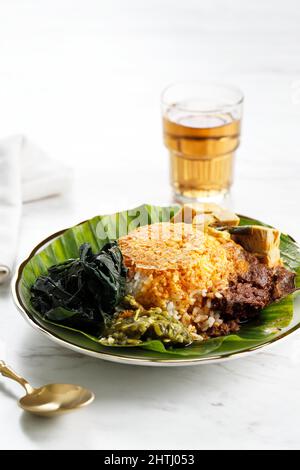 Nasi Padang consisting of white rice, rendang, egg, vegetables in a ...