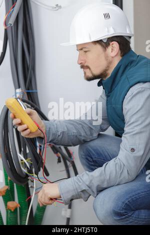 electrician measuring voltage of socket in new building Stock Photo - Alamy