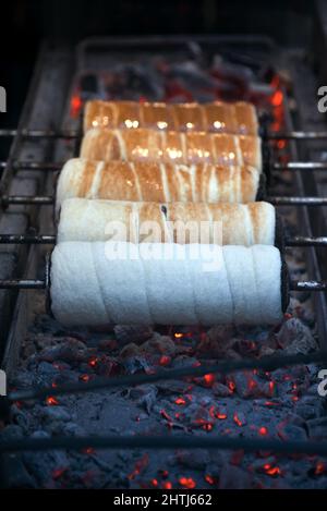 The baking of Kurtoskalacs, the traditional hungarian spit cake, in a ...