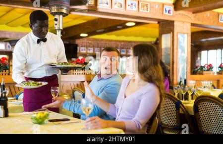 Dissatisfied guests conflicting with african american waiter in ...