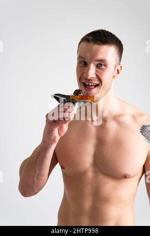 Man eats protein bar on white background isolated young snack healthy ...