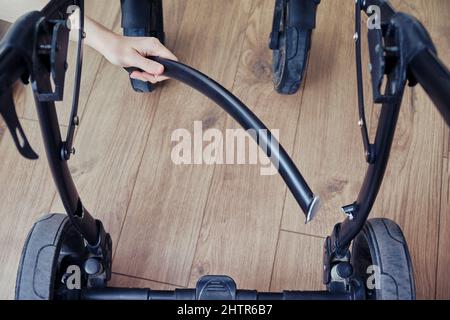 Broken chassis of a baby stroller, damage to the crossbar of the metal ...