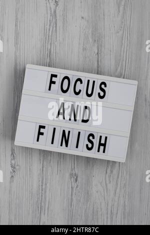 'Focus and Finish' on a lightbox on a white wooden background, top view ...
