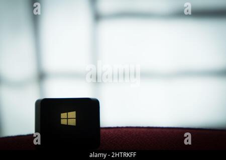 Windows start button of a keyboard in front of a window on a red ...