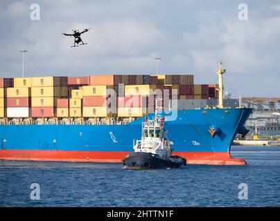 Drone flying above shipping containers on ship in port. Concept: drone ...