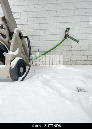 Closeup of a Frozen outdoor water spigot on white brick wall background ...