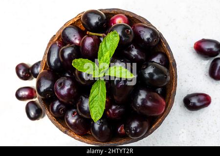Dark pink-red ripe Syzygium cumini fruits. Dark black java plum in a ...