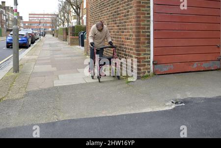 Elderly woman with wheeled rollator (wheeled zimmer frame walking aid ...