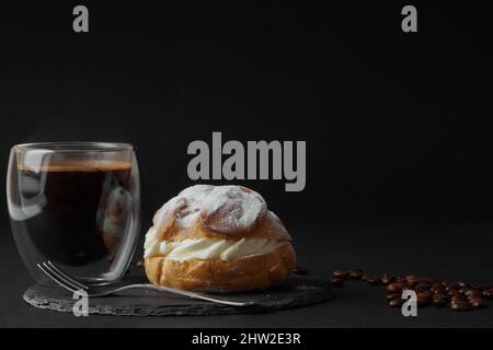 Large eclair Choux pastry cake with custard filling close-up in a plate ...