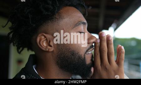 A Brazilian man praying to God opening eyes smiling Stock Photo - Alamy