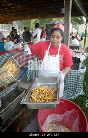 Woman making battered French Fries and Onion Rings for party in deep ...