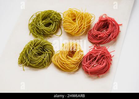 Multi-colored pasta nests on baking paper Stock Photo - Alamy