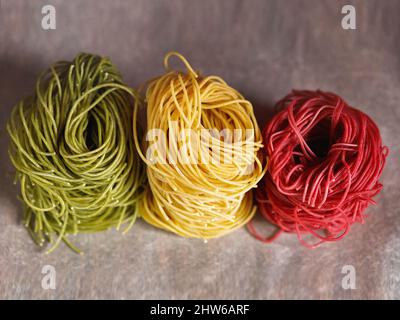 Multi-colored pasta nests on baking paper Stock Photo - Alamy