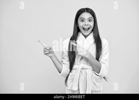 amazed kid in comfortable pajama sit pointing finger on herself on red ...