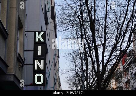 on a white illuminated cinema sign stands with black letters @office ...