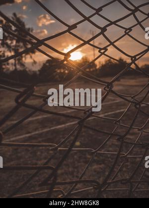 Sky through wire mesh fence. Blur background, close up view of link ...