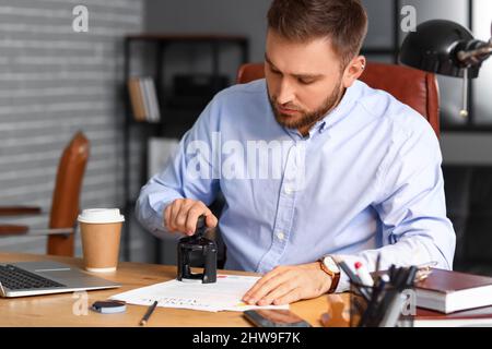 Male notary public attaching seal to document in office Stock Photo - Alamy