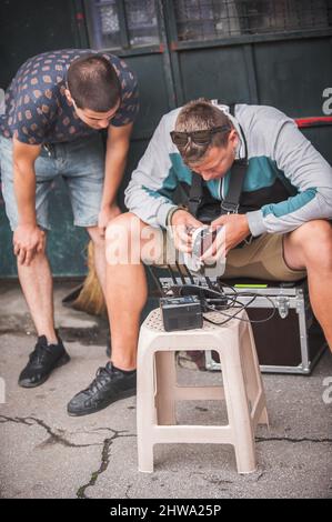 Behind the scenes. First assistant focus puller helps the cameraman ...