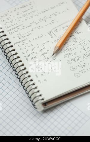 Math formulas are written in pencil on a piece of paper, math problems ...