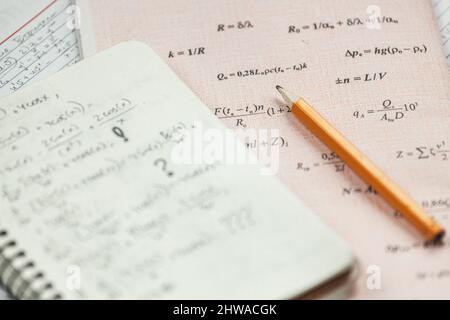 Math formulas are written in pencil on a piece of paper, math problems ...