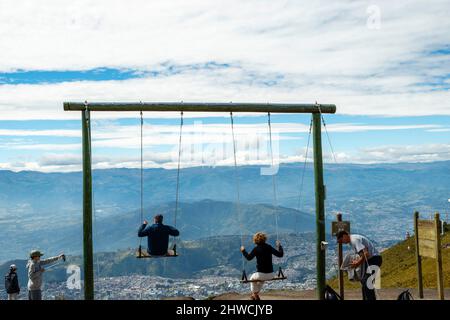 Tourists swing over Quito. High-angle view of greater Quito from Ruta a ...