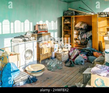Cluttered storeroom barn with old furniture and assorted debris ...