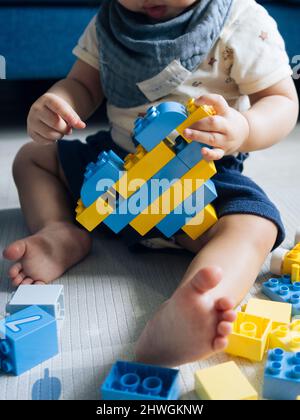 Baby playing with blue and yellow lego bricks Stock Photo - Alamy