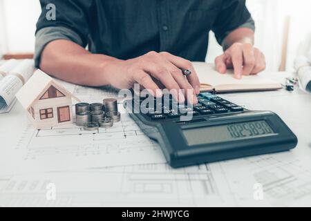 Architect engineer use calculator check cost house design on bueprint ...