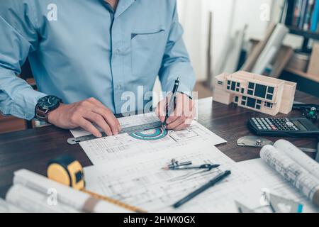 Architect engineer use pen and angle protector drawing design working ...