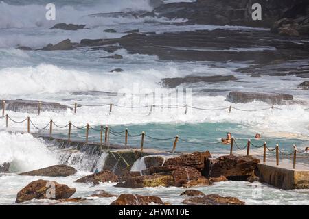 Avalon Beach Rockpool with wild ocean surf and people swimming in the ...