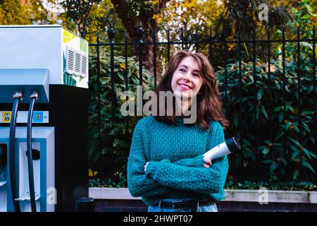 Woman standing with arms crossed at petrol pump station Stock Photo - Alamy