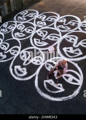 Painter painting faces on rooftop Stock Photo - Alamy